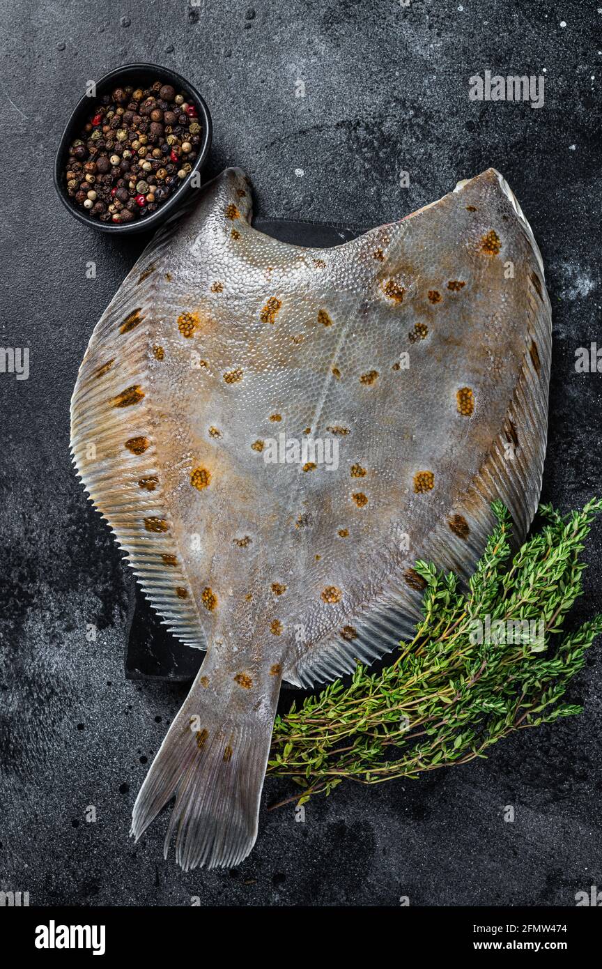Raw flounder flatfish fish on marble board with thyme. Black background ...