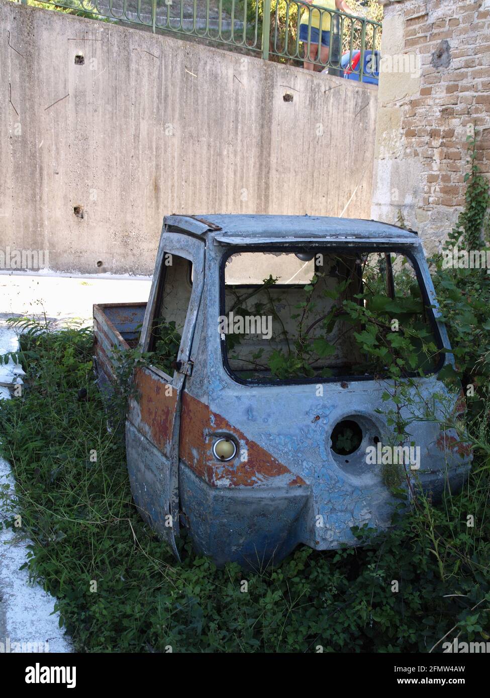 Rusty three wheeled pick up in overgrown weeds in Karousades, Corfu ...