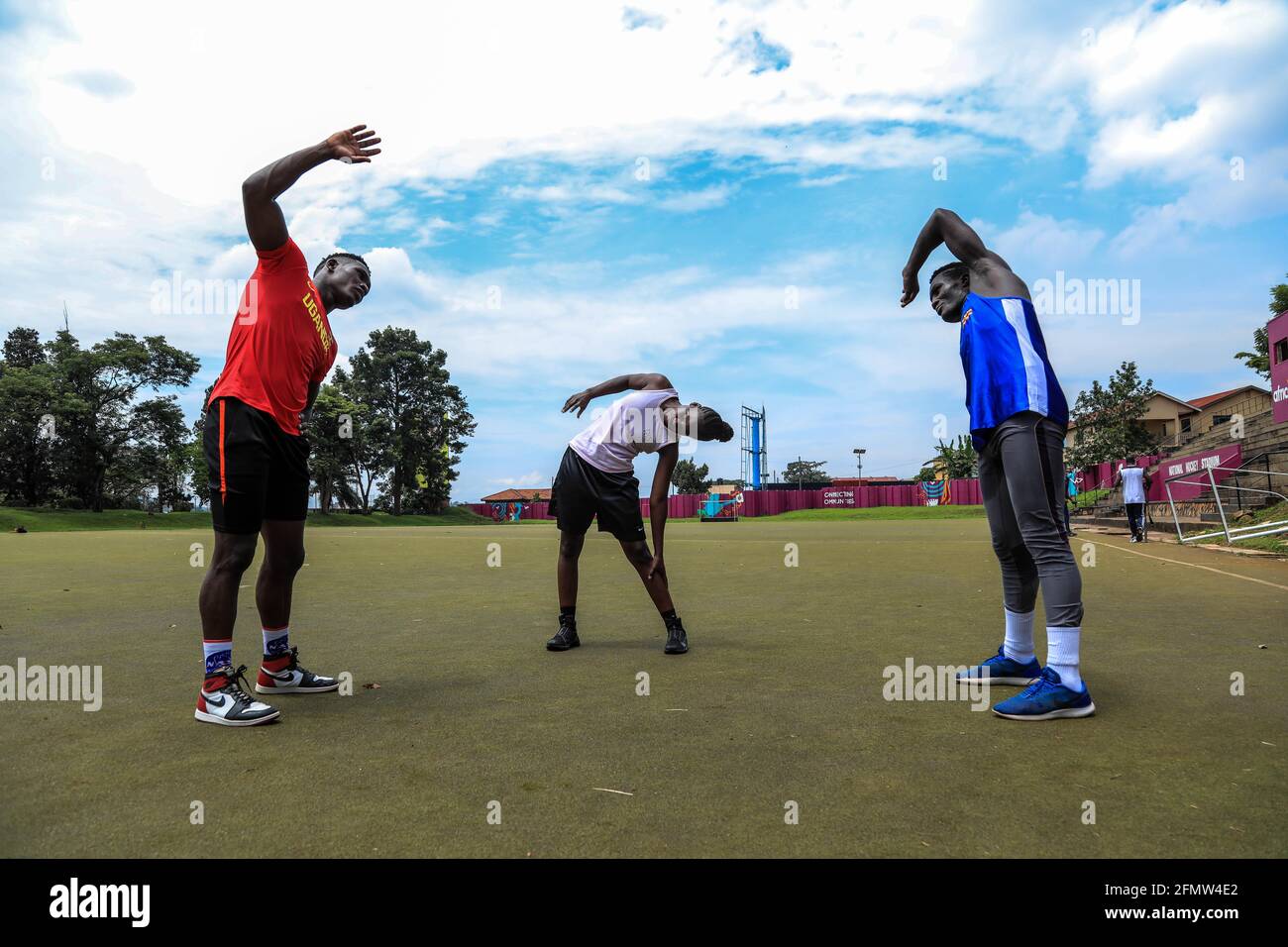 Kampala, Catherine Nanziri (C) and David Ssemujju stretch after a ...