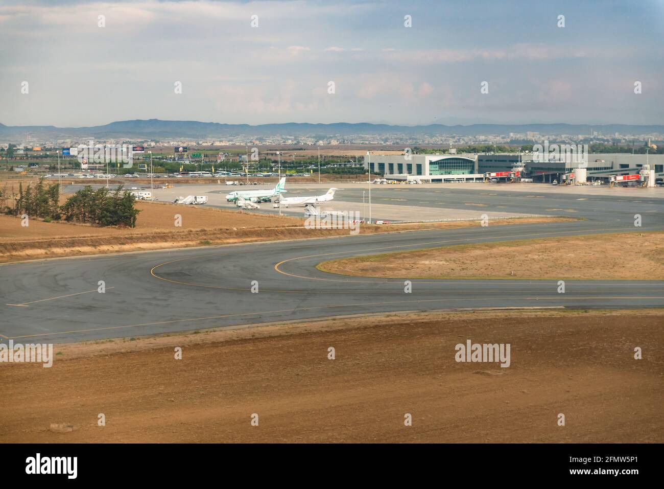 Paphos Airport in Cyprus. Planes on the runway and at the hangars ...