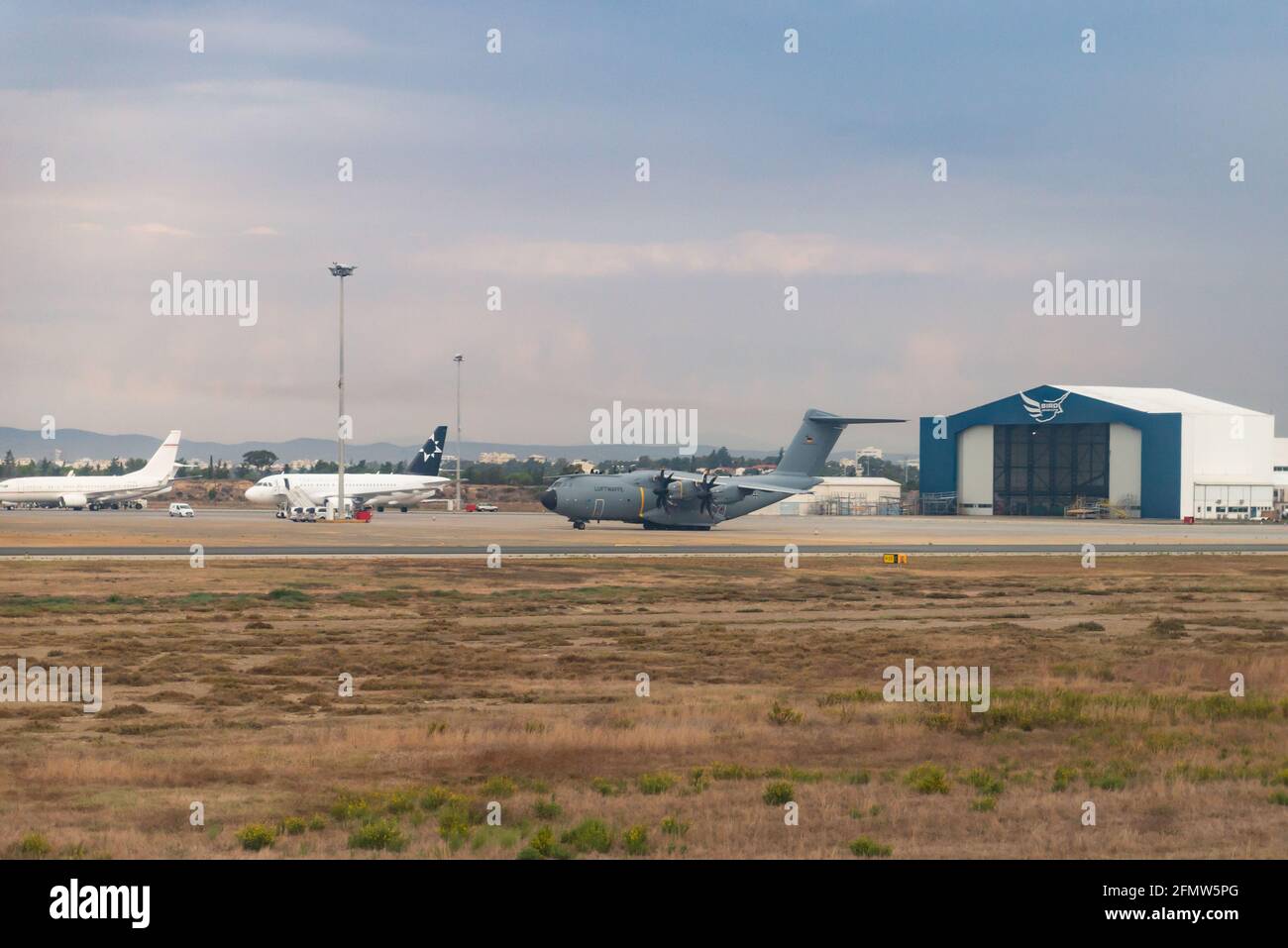 Paphos Airport in Cyprus. Planes on the runway and at the hangars ...