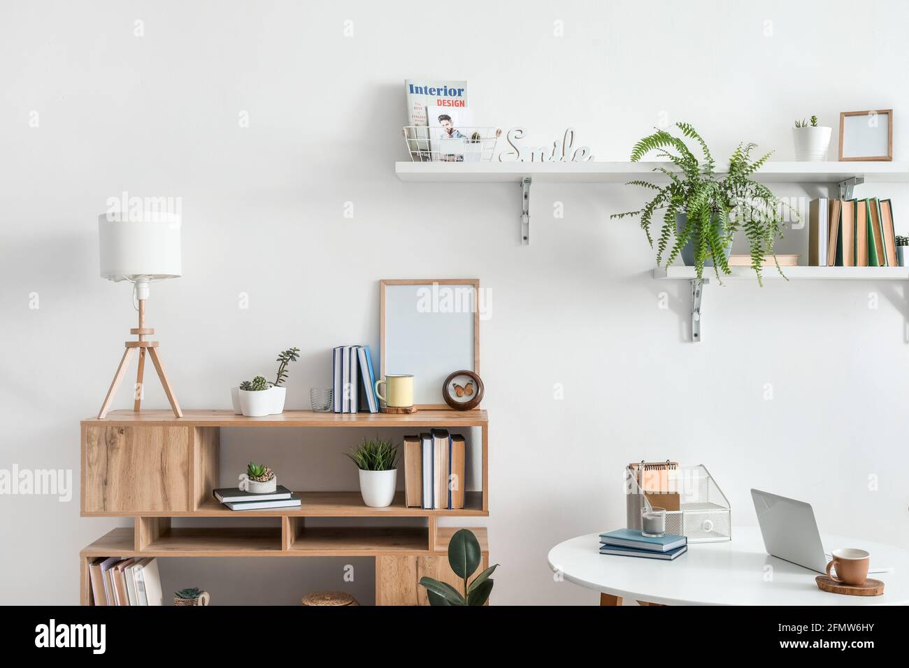 Shelf unit with books and table in interior of room Stock Photo - Alamy