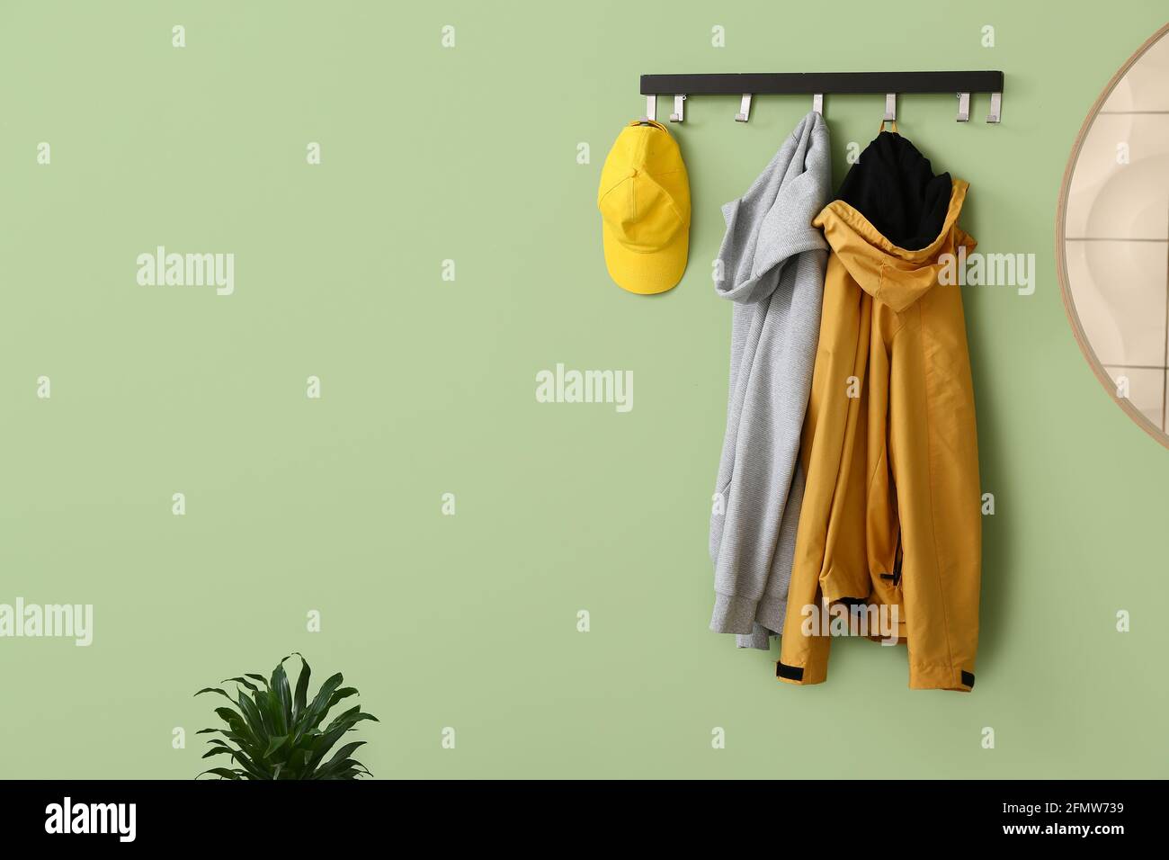 Stylish clothes hanging on wall in hall Stock Photo - Alamy