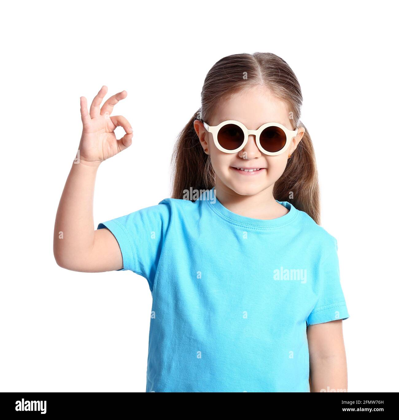 Cute little girl wearing stylish sunglasses and showing OK on white ...