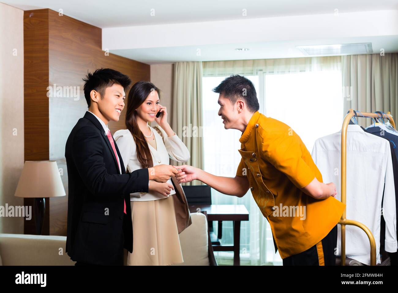 Baggage porter or bellboy or page receiving tip for delivering the ...