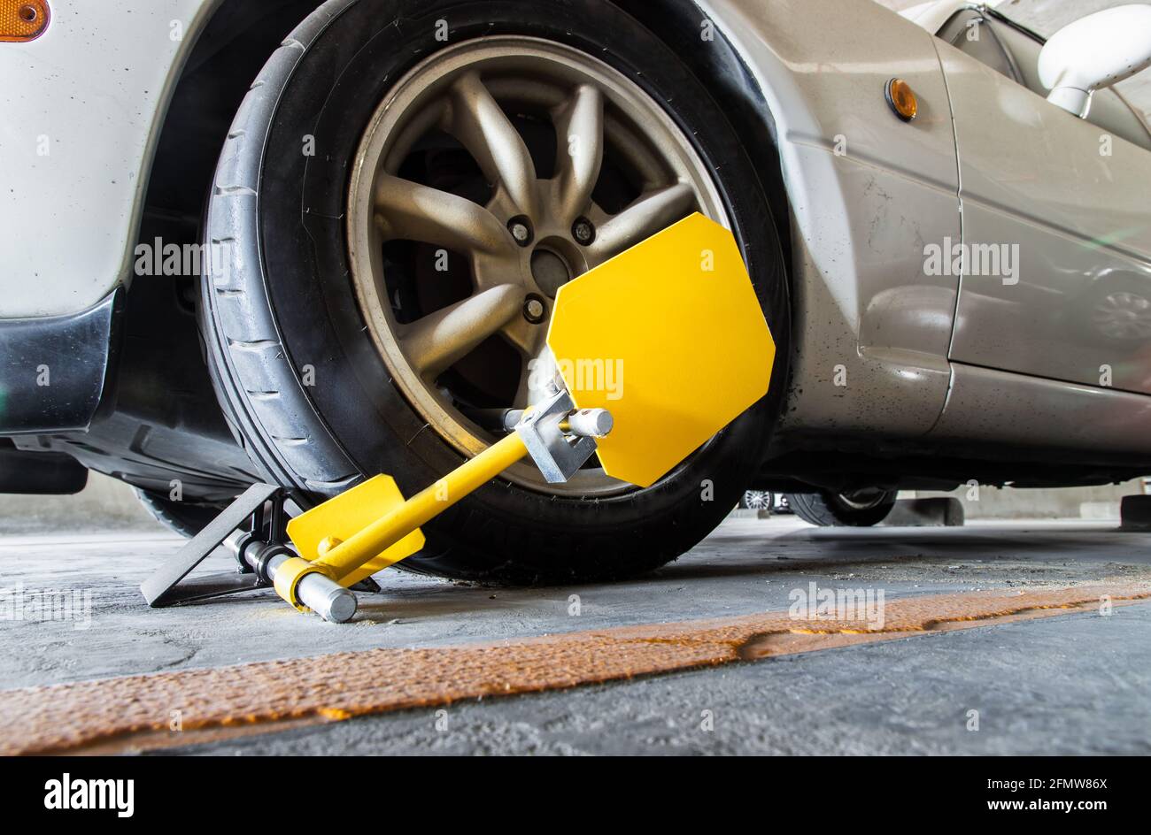 Close-up of Car wheel blocked by wheel lock because illegal parking ...