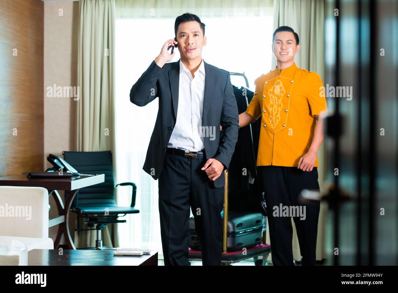 Portrait of guest and bell boy in hotel room Stock Photo - Alamy