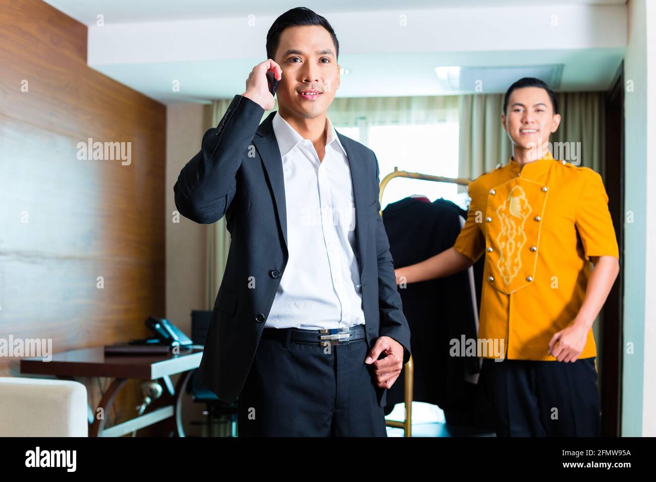 Portrait of guest and bell boy in Asian hotel room Stock Photo - Alamy