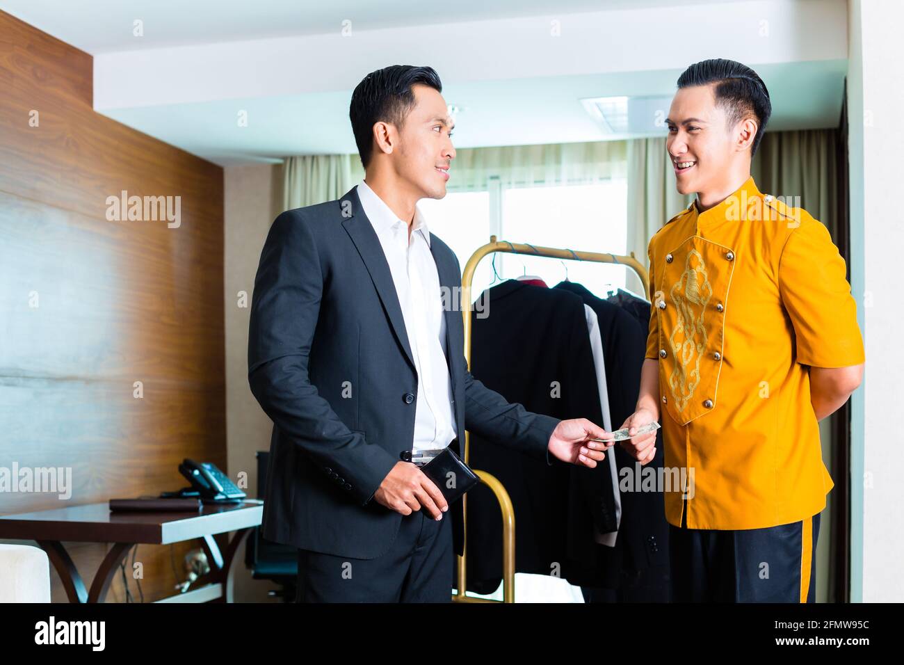Guest giving tip to a bell boy in hotel room Stock Photo - Alamy