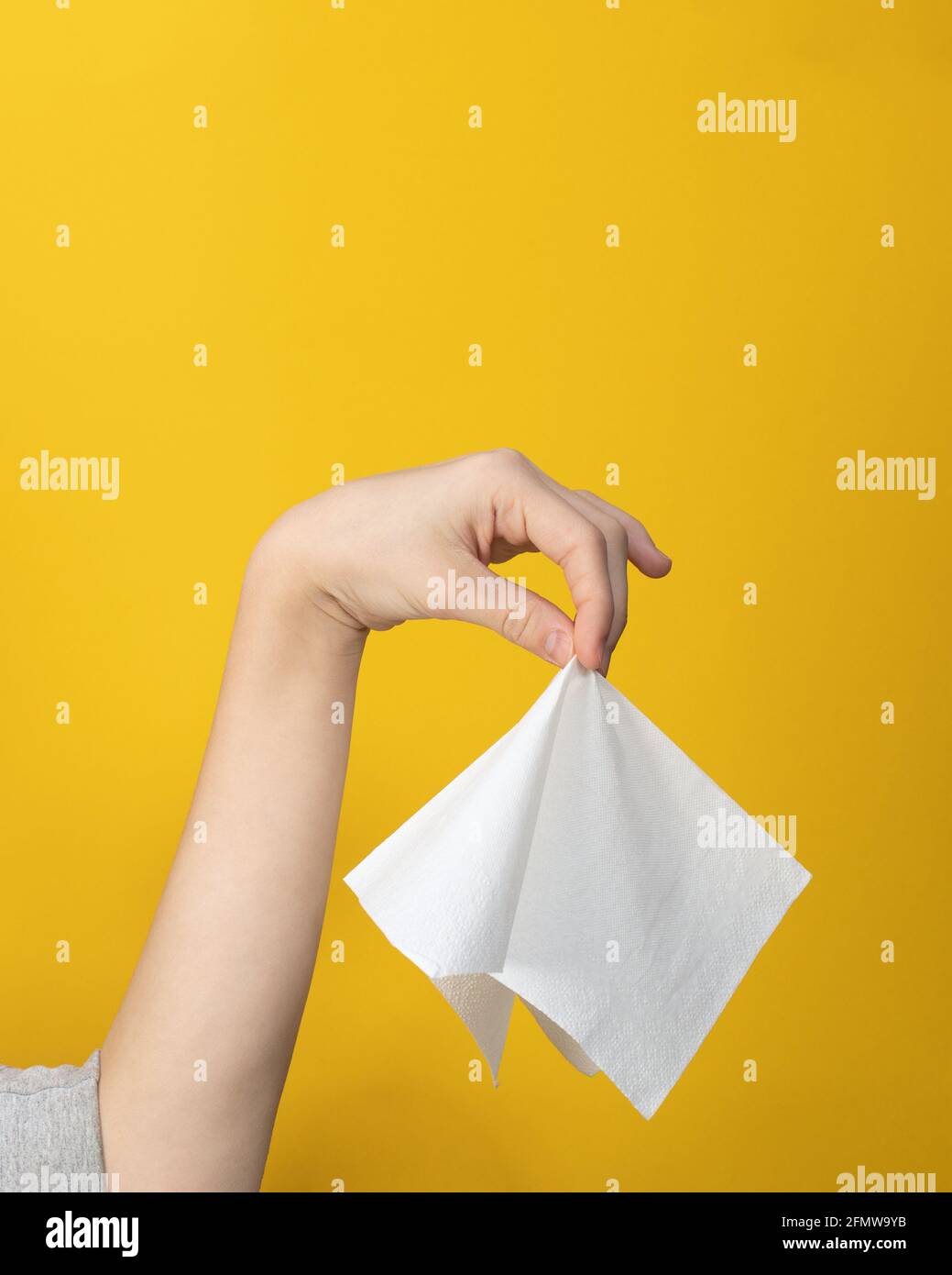 Close-up of hand gesture holding napkin neatly in middle with fingers ...