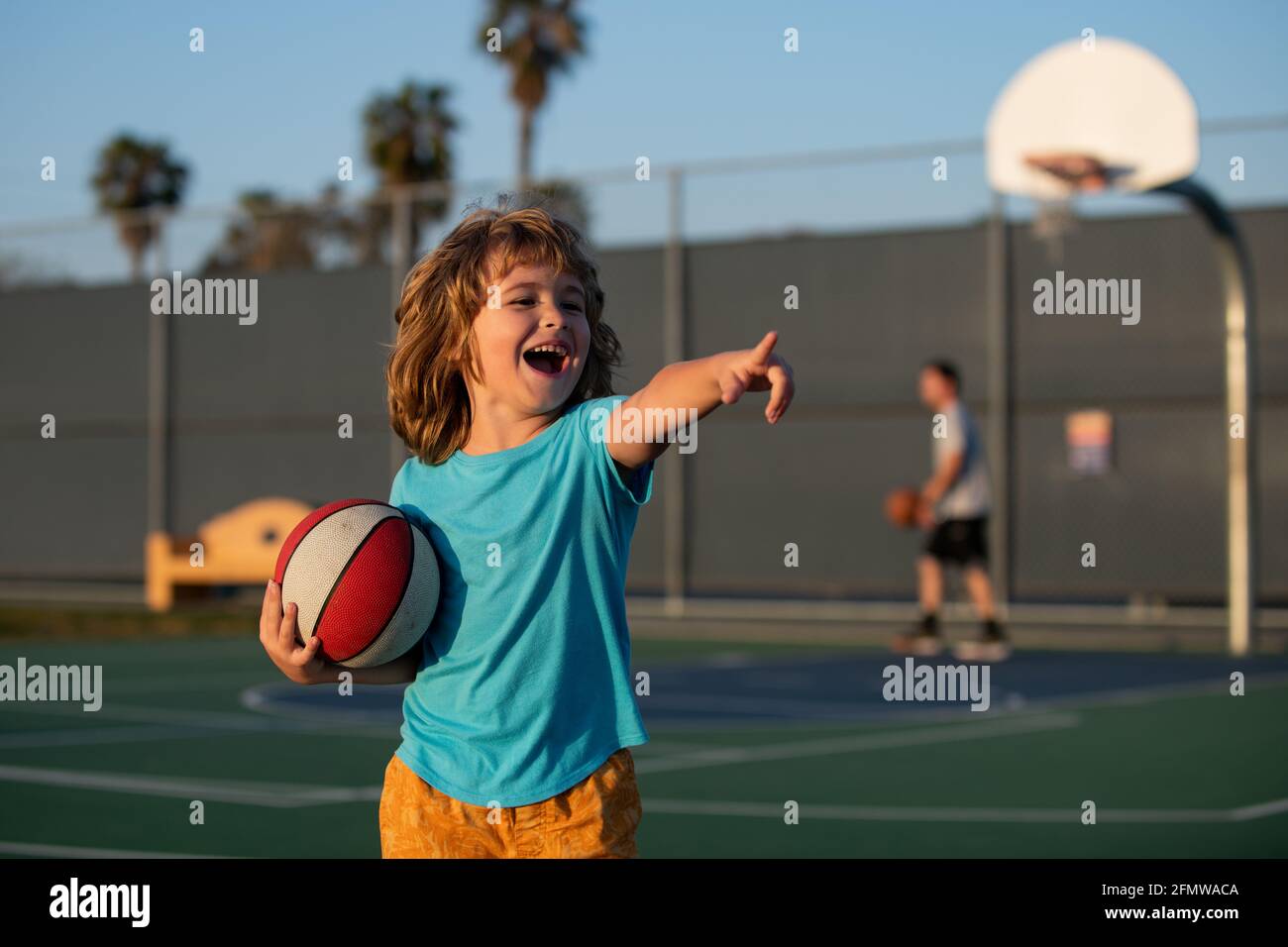 Basketball kids game. Cute little boy laughing and holding a basketball ...