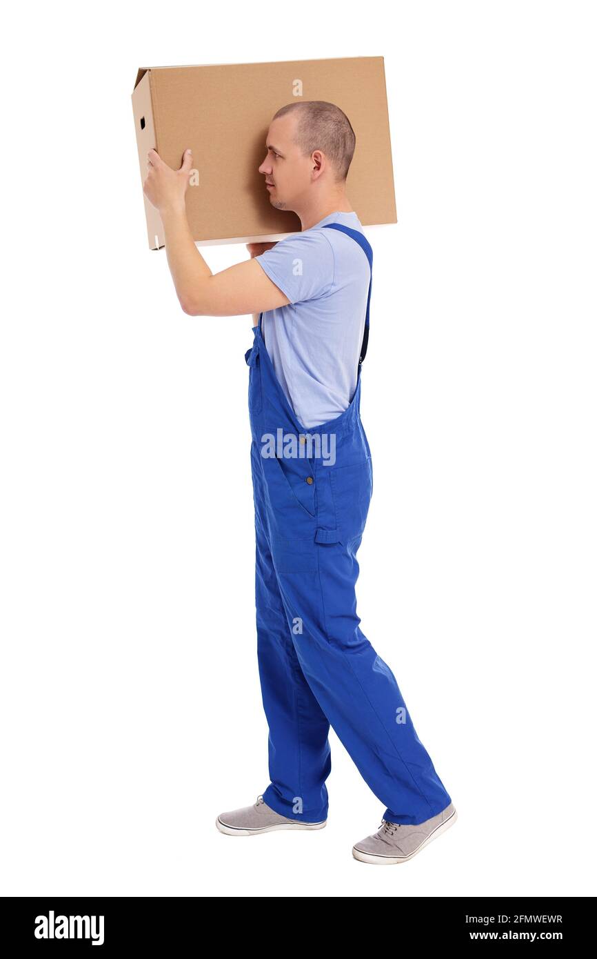 side view of handsome man loader in uniform walking with big box on his ...