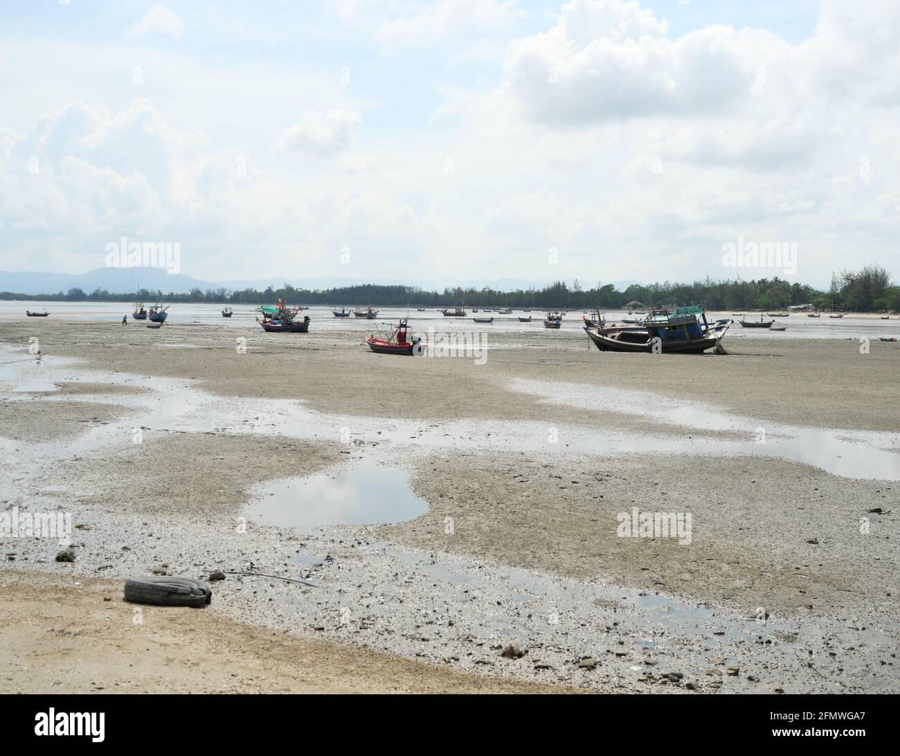 Sand and mud in water phenomenon at low tide, Fishing boat on the beach ...