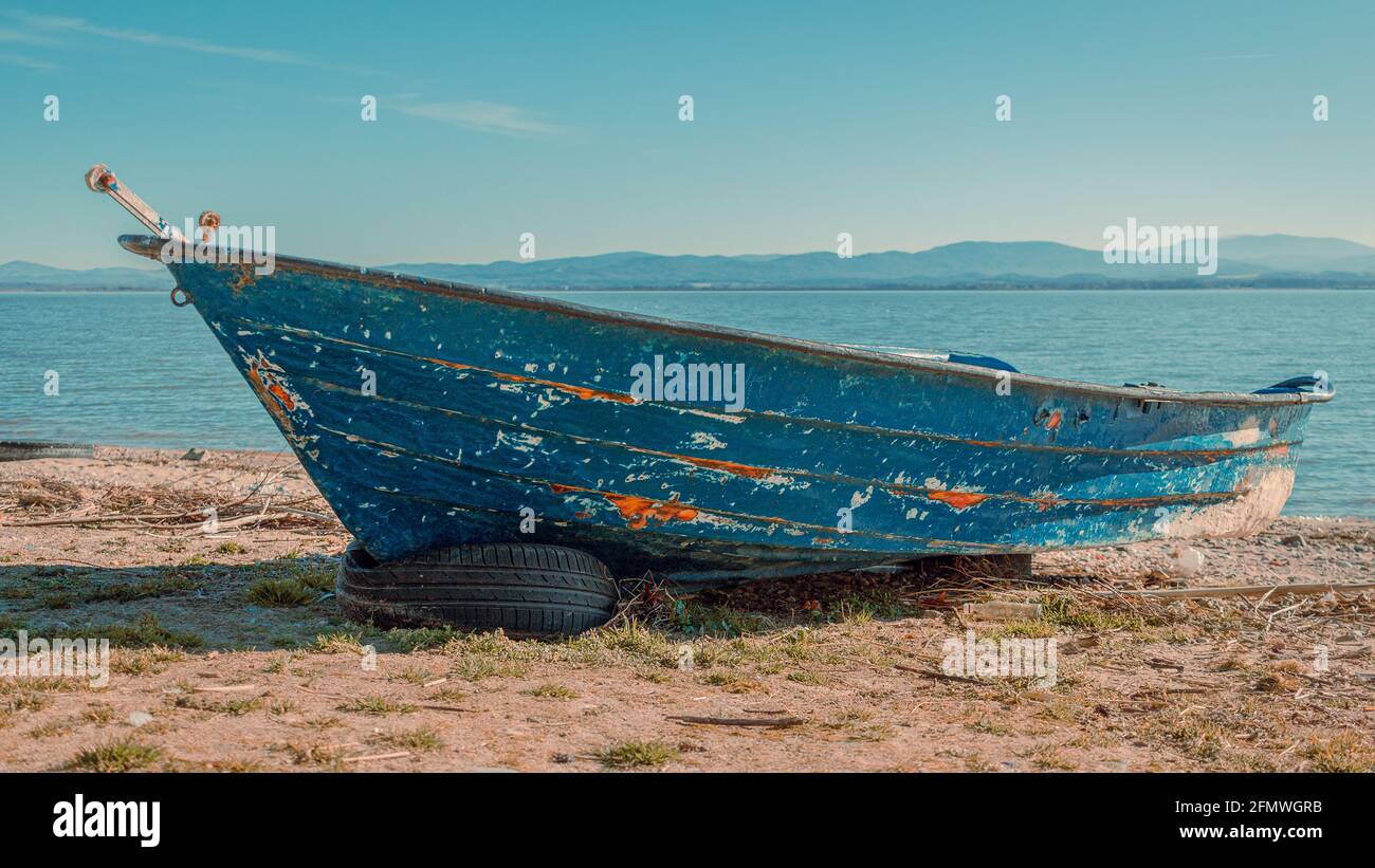Blue boat offshore the lake with mountains in the background Stock ...