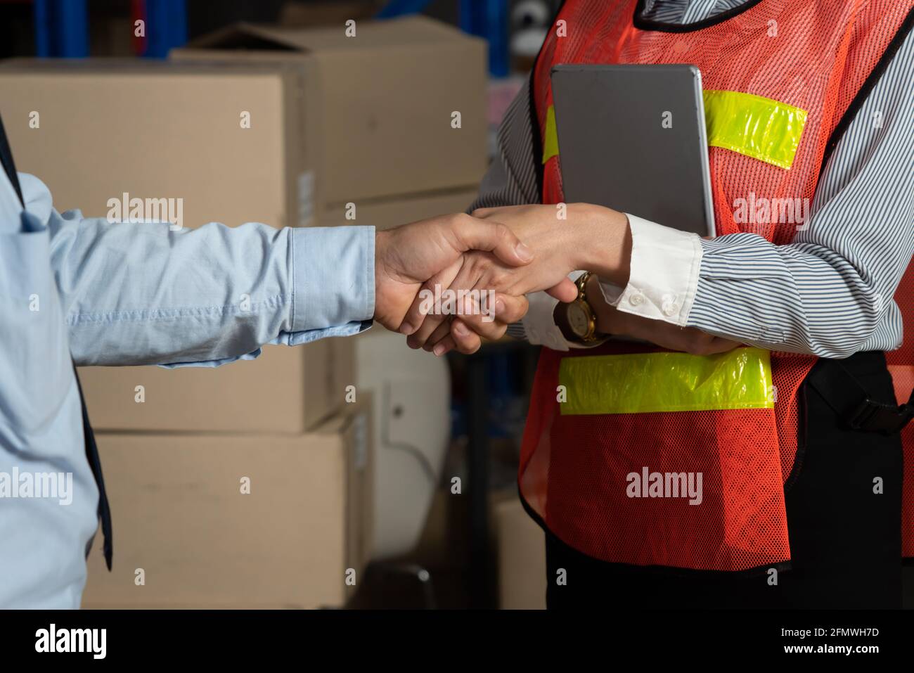 Warehouse worker handshake with manager in storehouse . Logistics ...