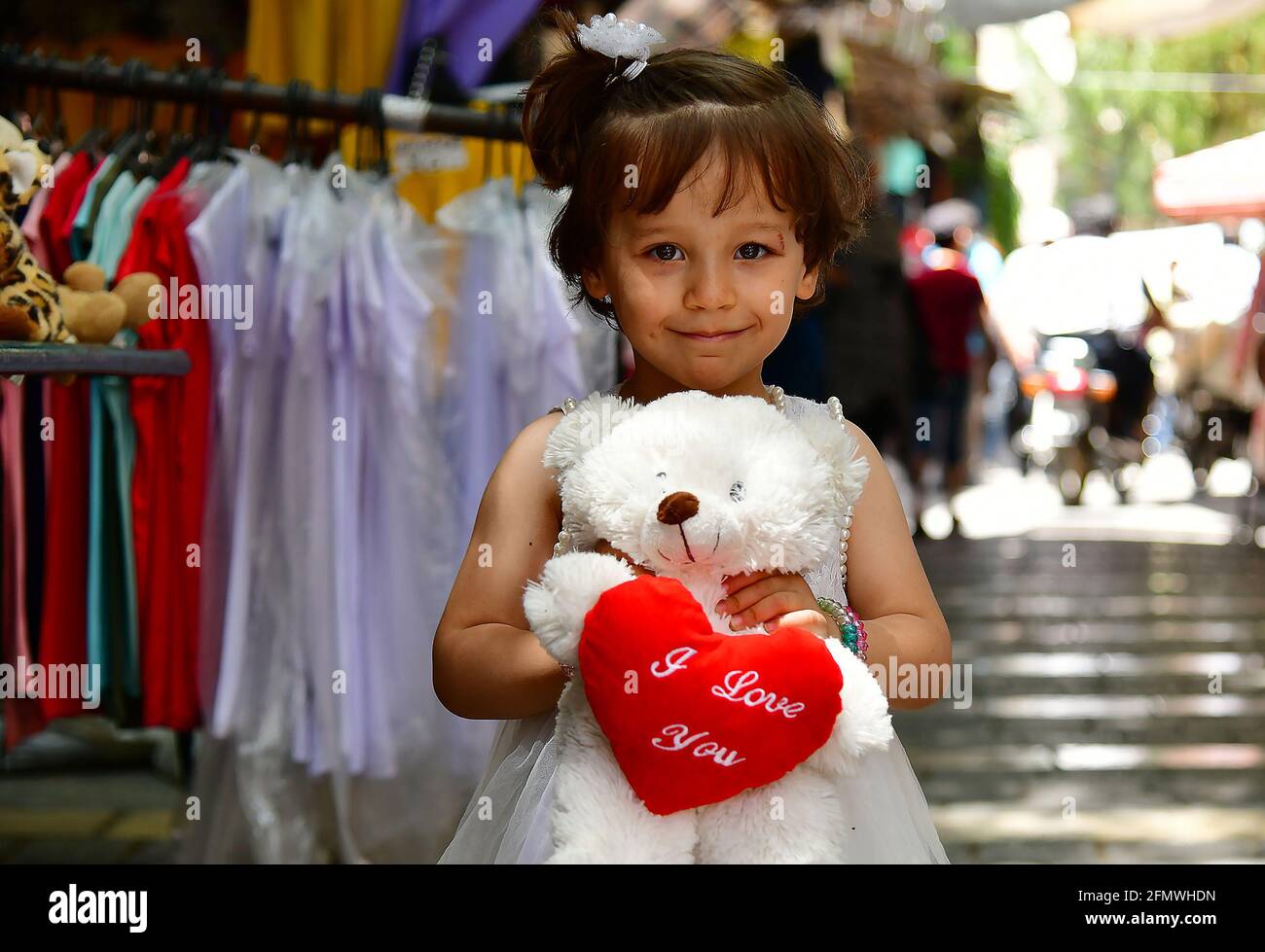 Damascus, Syria. 11th May, 2021. A girl poses for a photo with a teddy ...