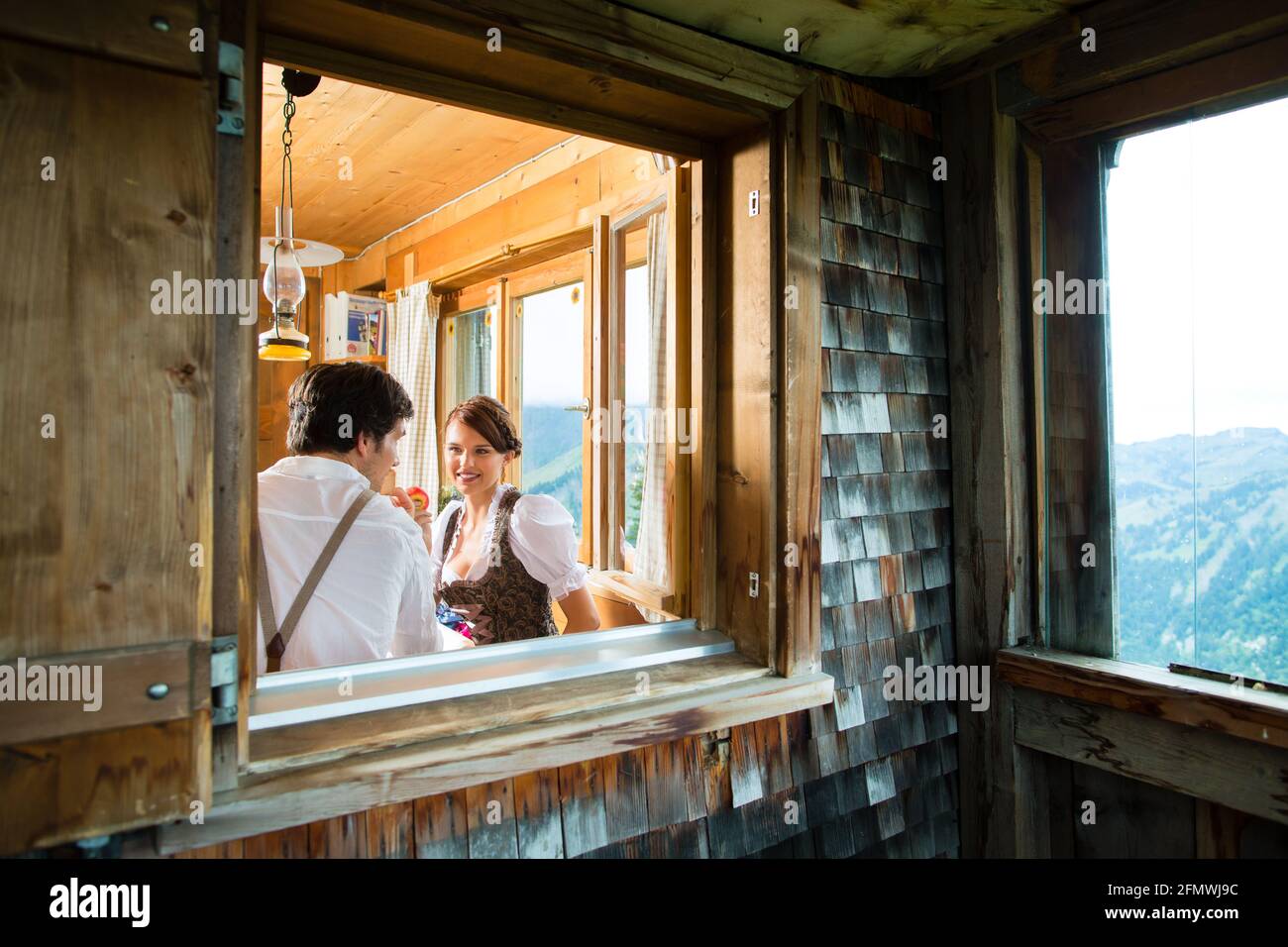 Couple in a traditional mountain hut having a meal - view through the ...