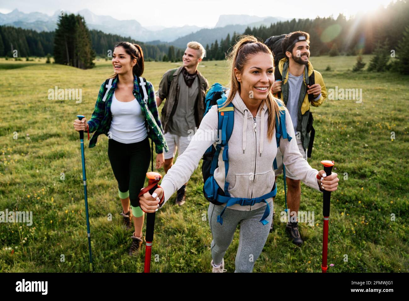Group of fit healthy friends trekking in the mountains Stock Photo - Alamy
