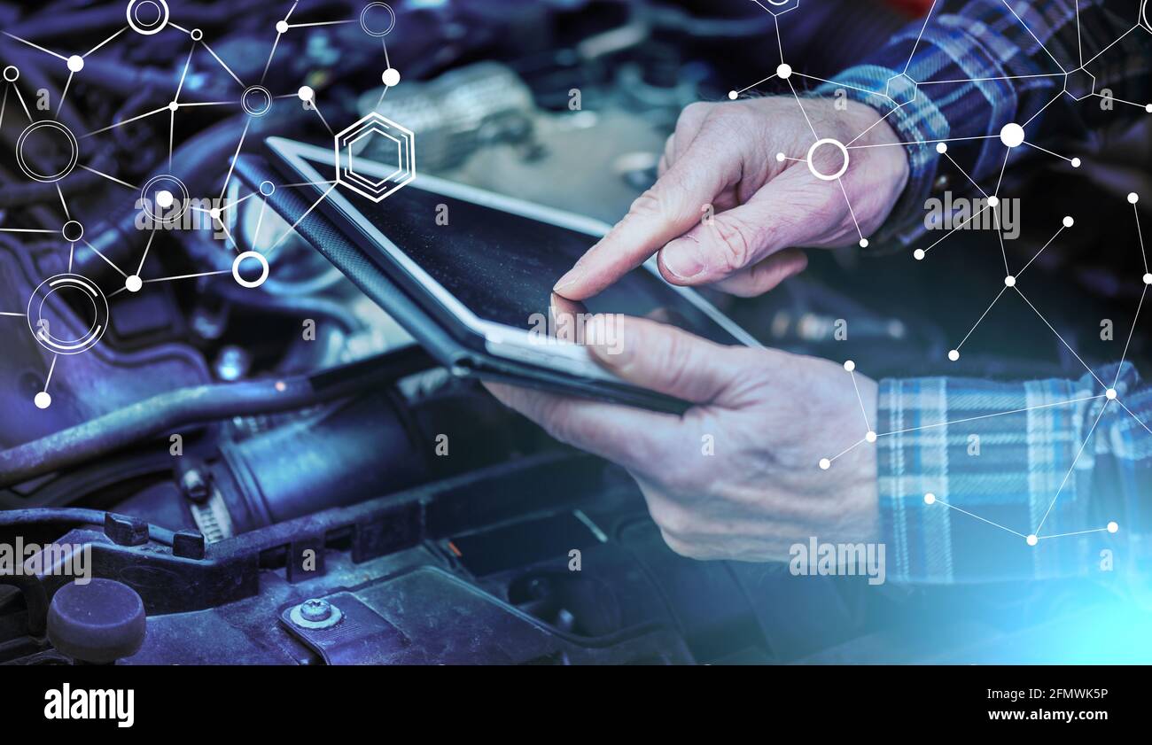 Car mechanic using digital tablet for checking car engine; light effect ...
