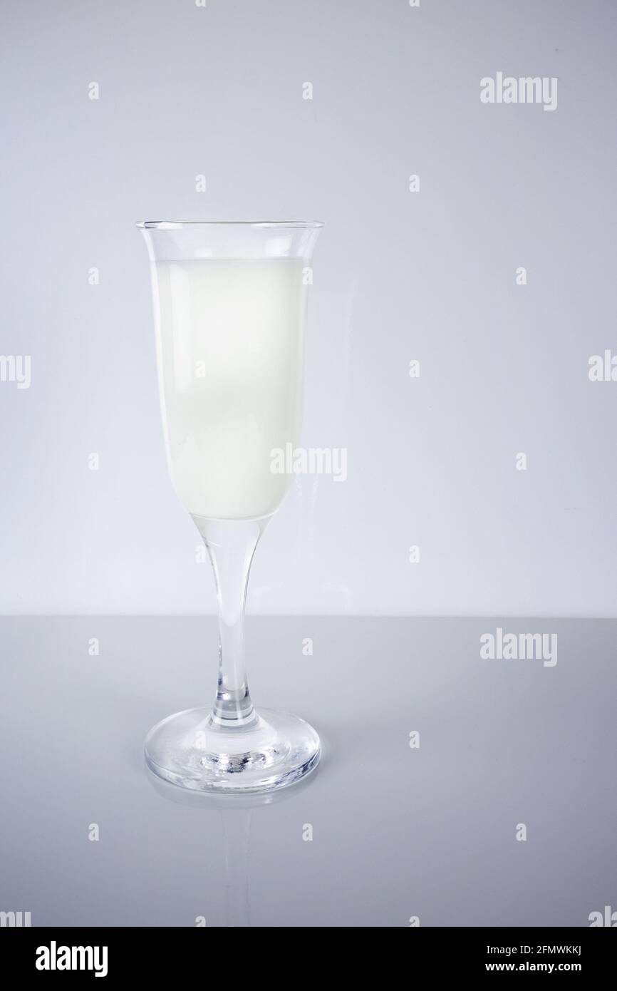 Milk in transparent wineglass on light background Stock Photo - Alamy