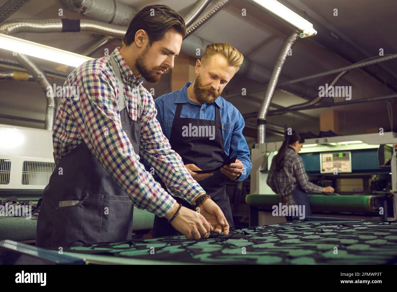 Footwear manufacturing workshop manager checking the quality of work of ...
