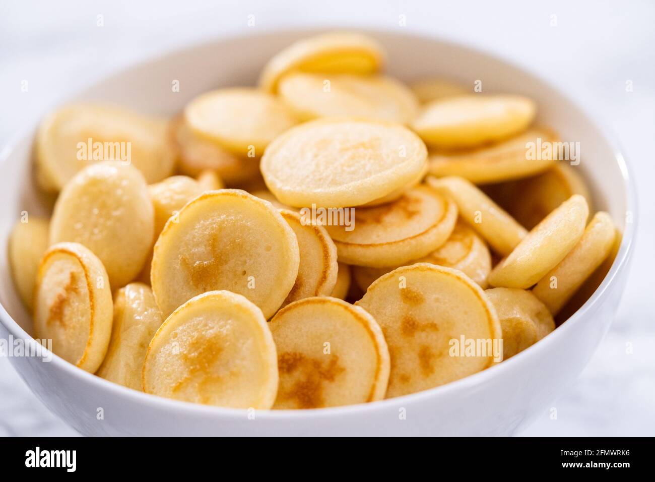 Freshly made mini pancake cereal in a white bowl Stock Photo - Alamy