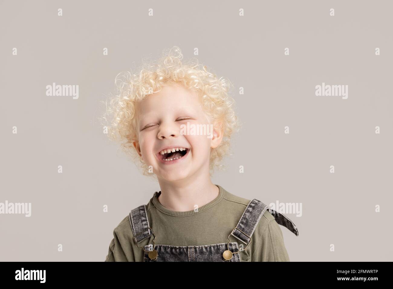 Portrait of little preschool boy posing isolated over gray studio ...