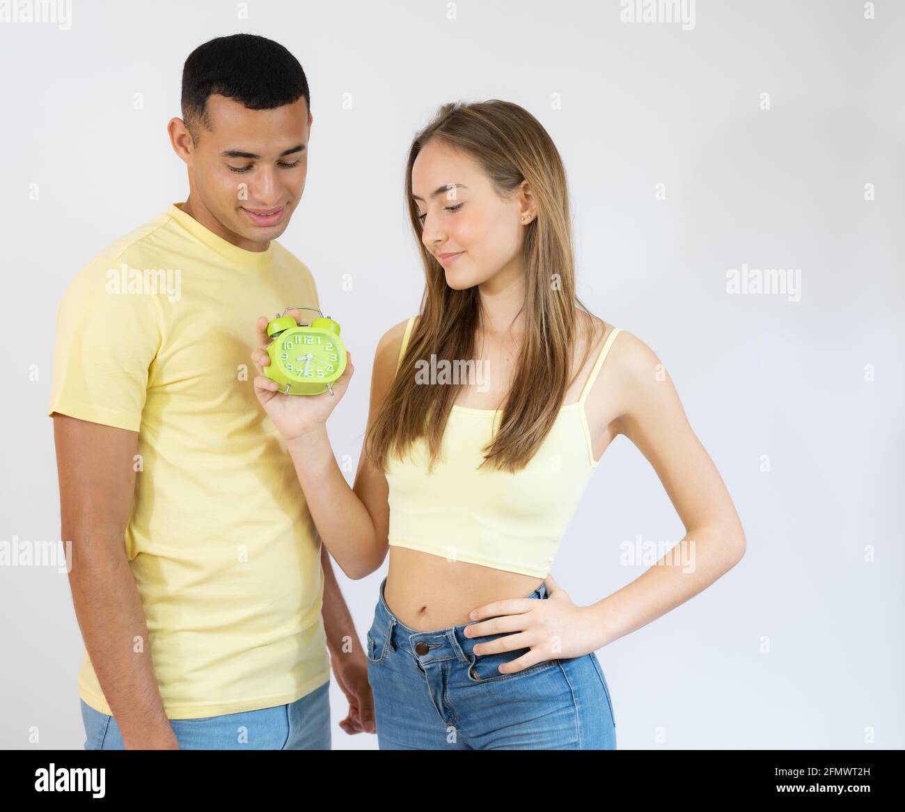 Image of cute young loving couple holding alarm clock isolated over ...