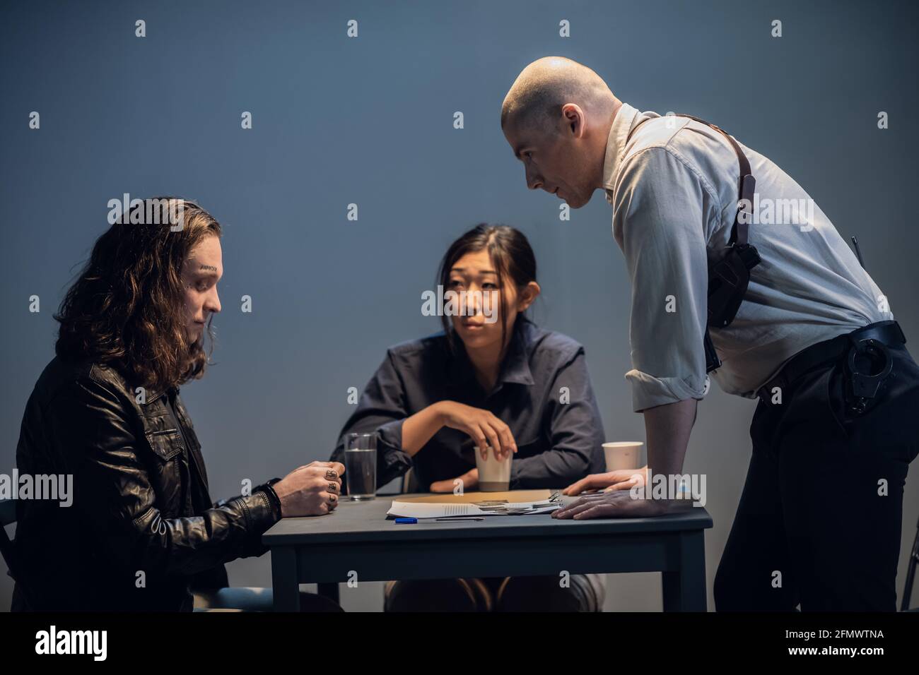 An experienced investigator and his assistant conduct an interview at ...