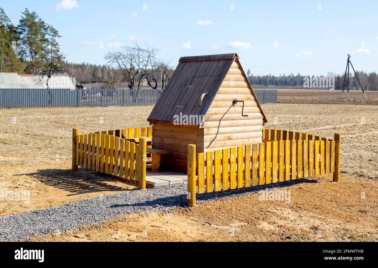 Beautiful and modern wooden well with water in a village in nature ...