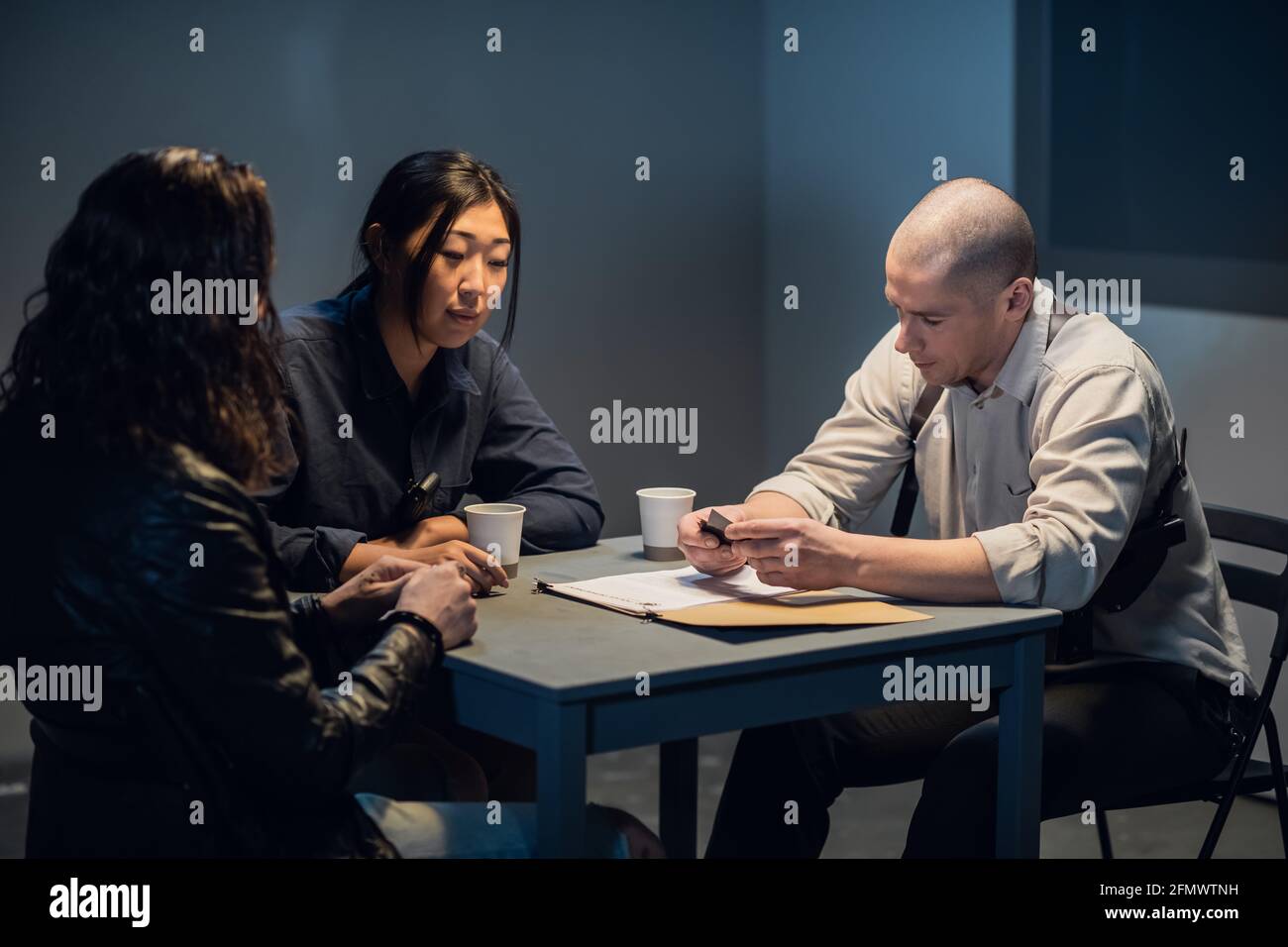 In the interrogation room, the investigator and the officer are talking ...