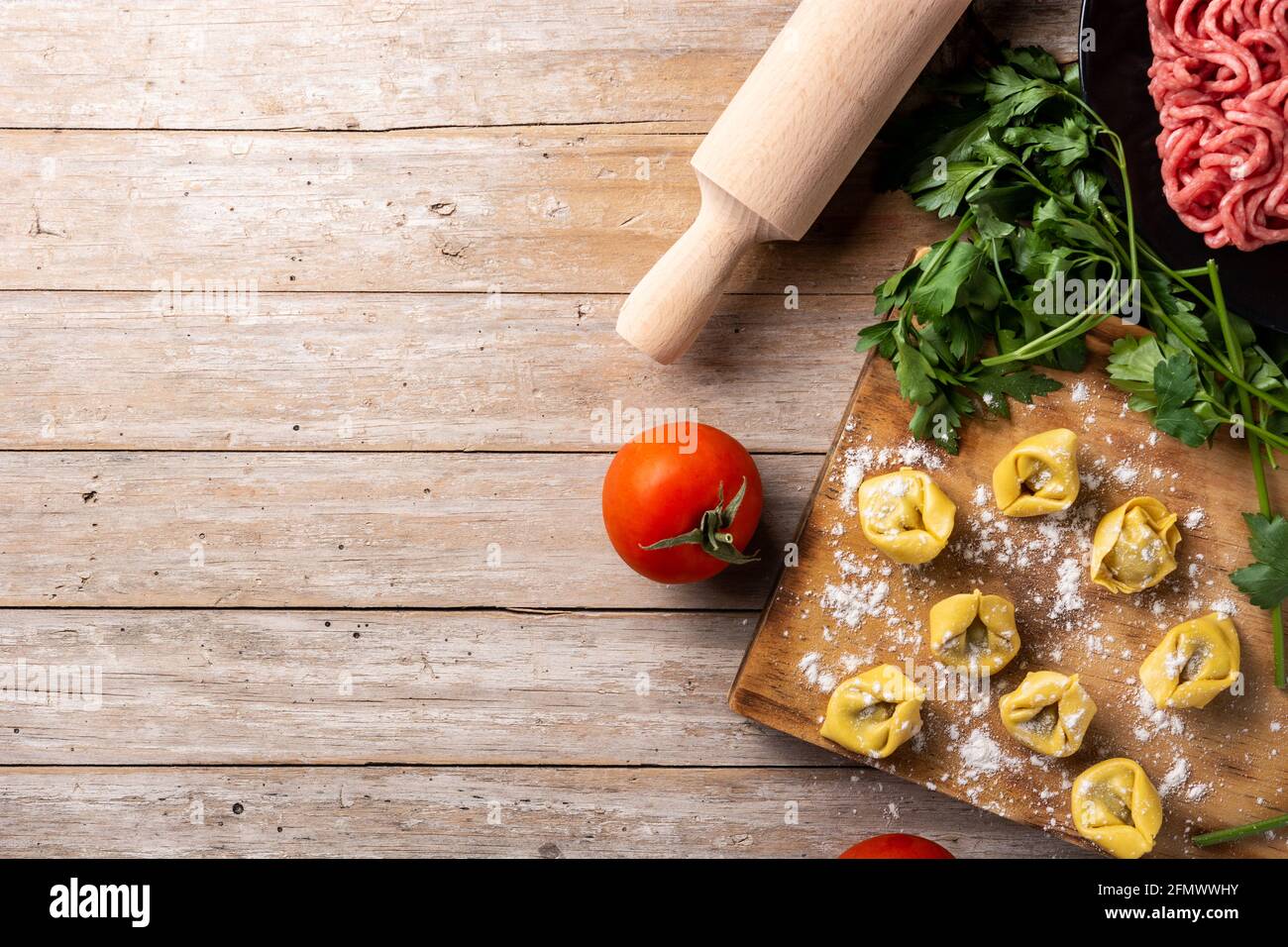 Uncooked pelmeni dumplings on rustic wooden table. typical russian food ...