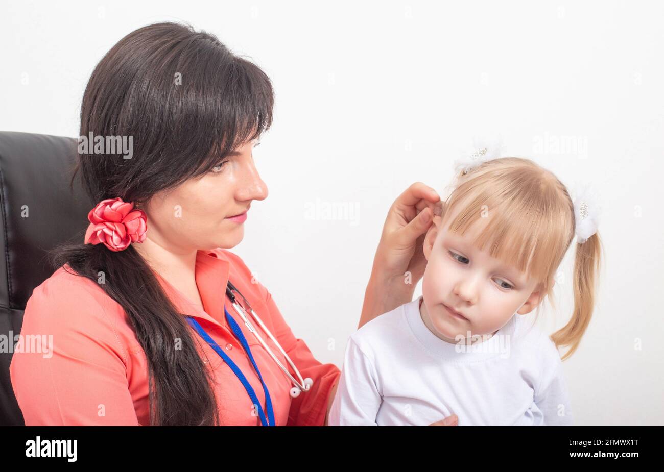 Doctor pediatric otolaryngologist examines the ear of a child of a ...
