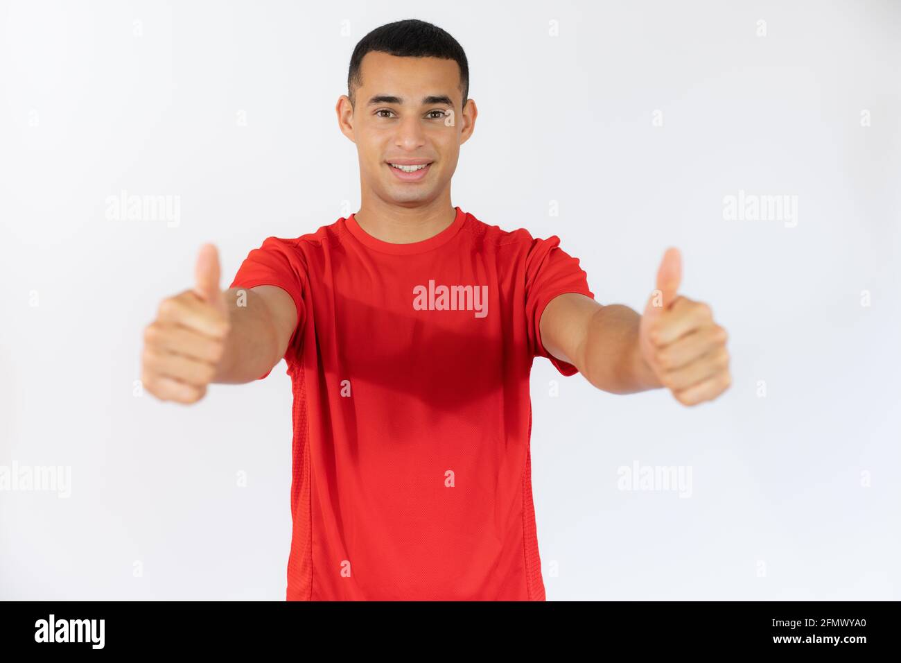 Young smiling man with thumbs up over white background Stock Photo - Alamy
