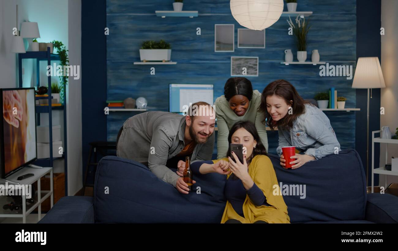 Multiracial friends hanging out together socializing while looking at ...