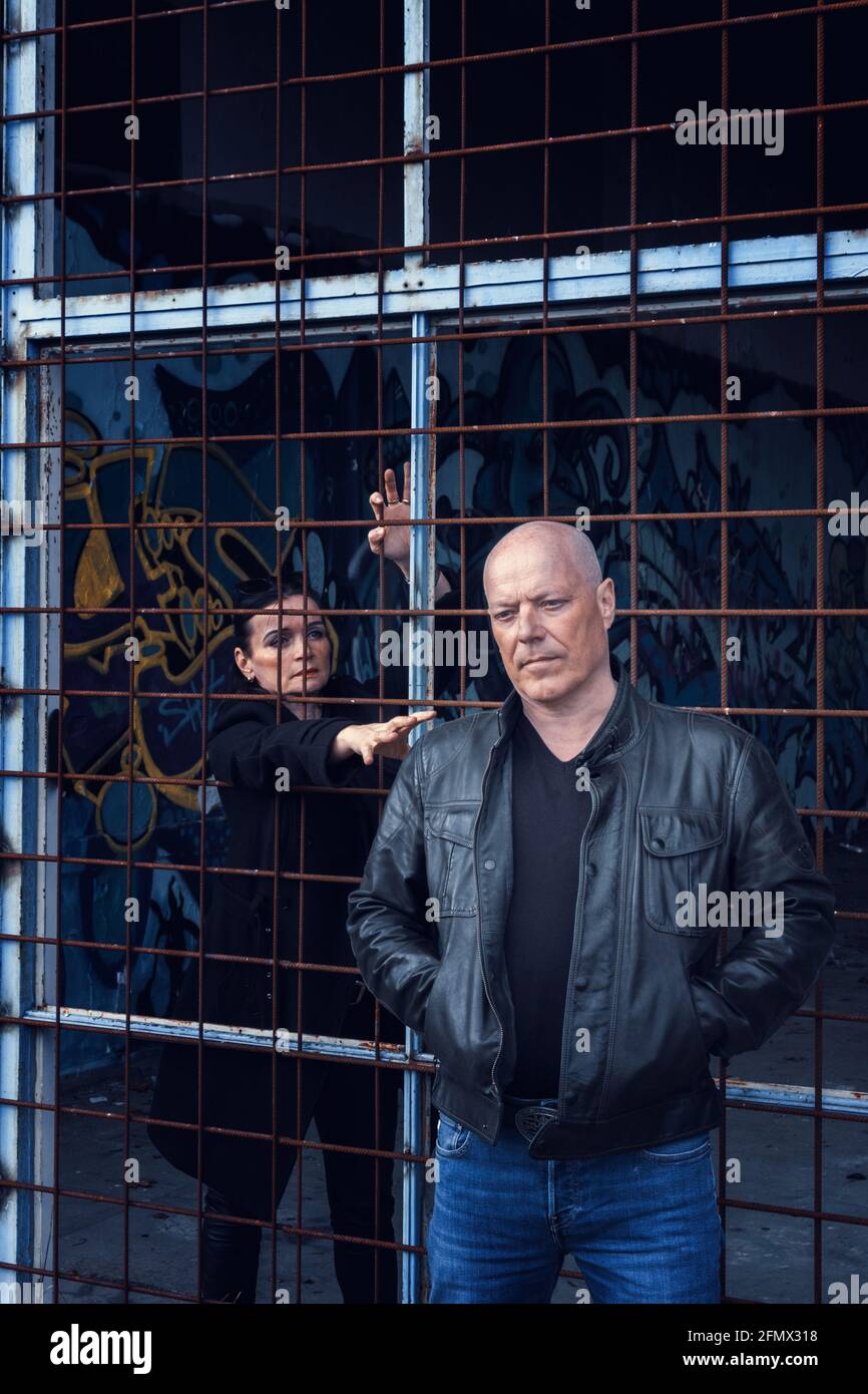 woman in a cage reaching her arm to man who stands outside Stock Photo ...