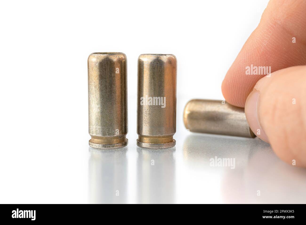 Man take bullet isolated on white background, 9mm gun shells close up ...