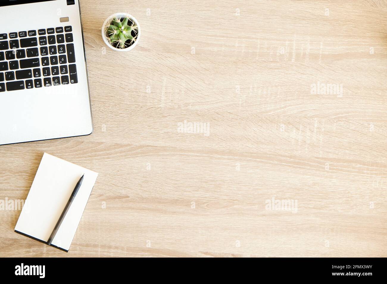Close up composition: laptop computer keyboard, blank page notebook ...