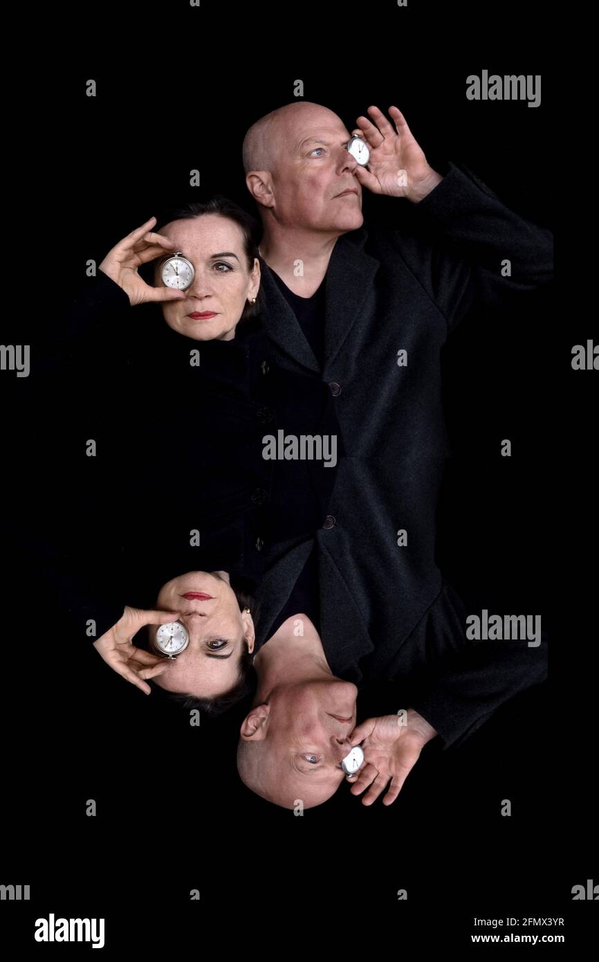 mirrored image of a couple holding pocket watch to their eyes Stock ...