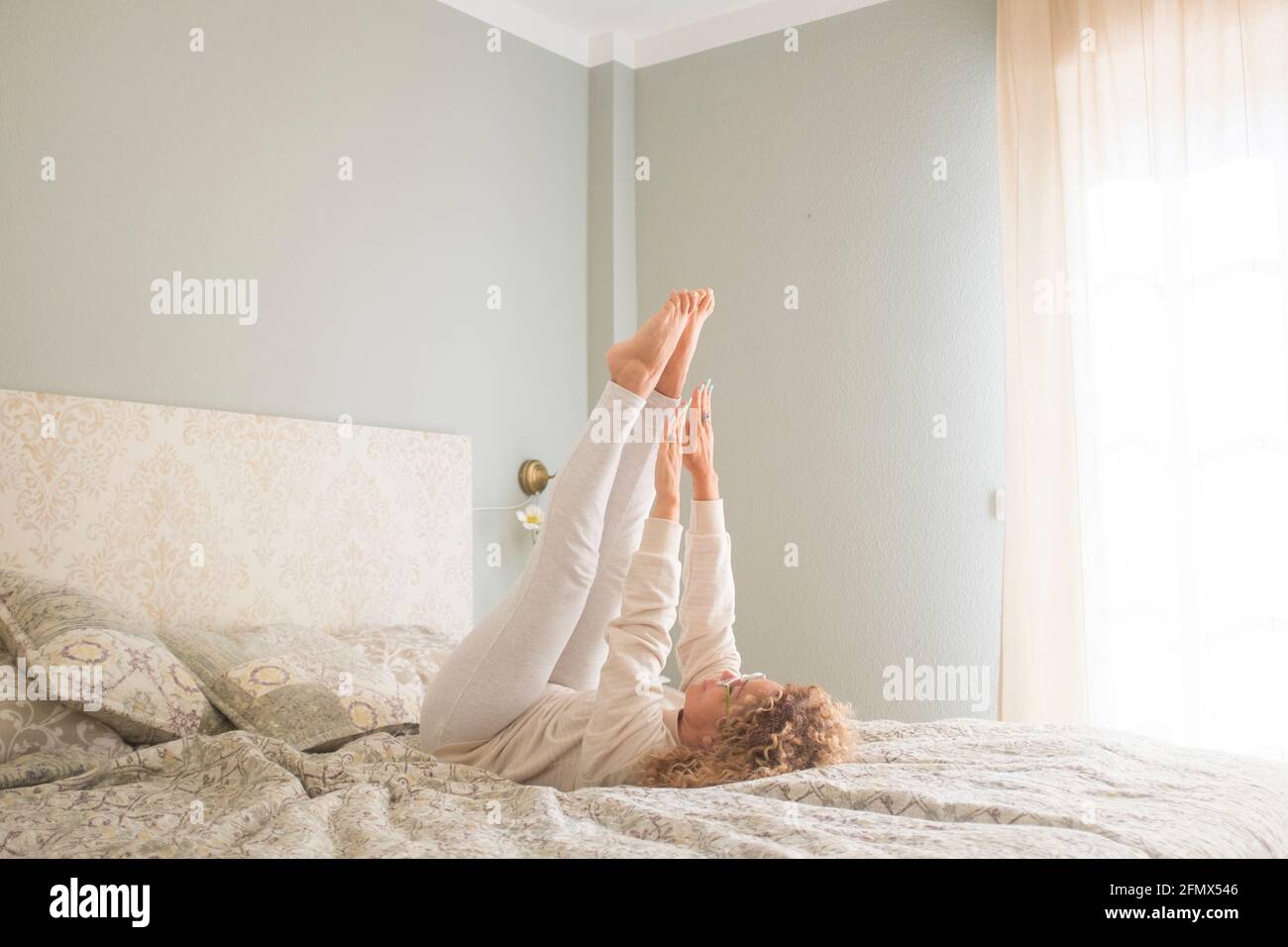 Woman do exercise active lifestyle laying on bed in the bedroom ...