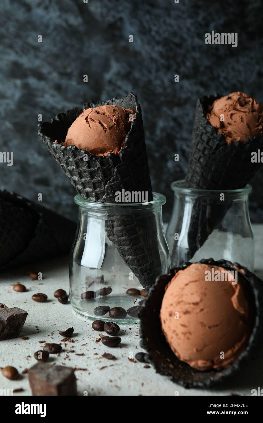 Black cones with ice cream against dark background Stock Photo - Alamy