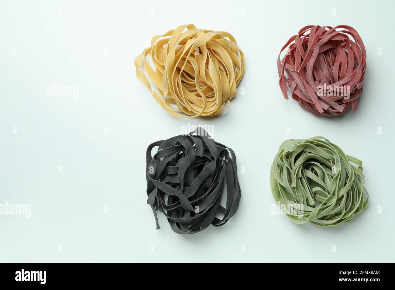 Different uncooked multicolor pasta on white background Stock Photo - Alamy