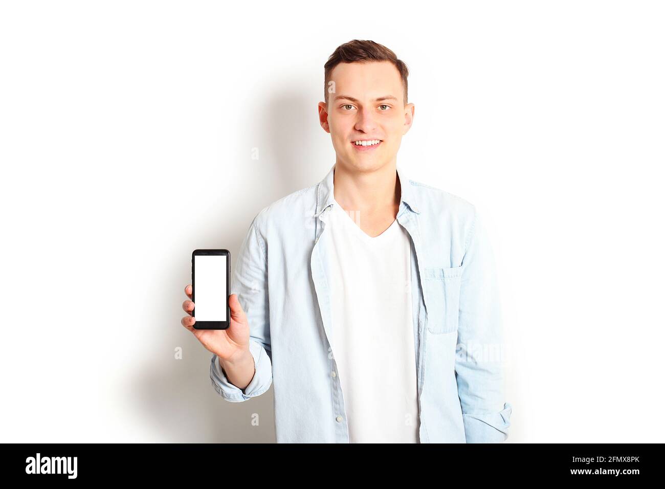 Young attractive man showing display of new touch mobile cell phone ...