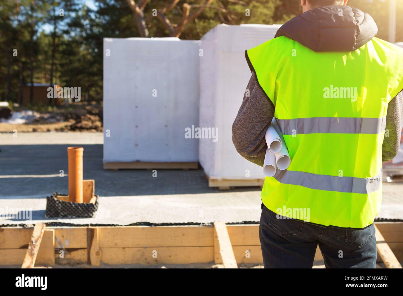 The project architect's back is on the construction site of a house ...
