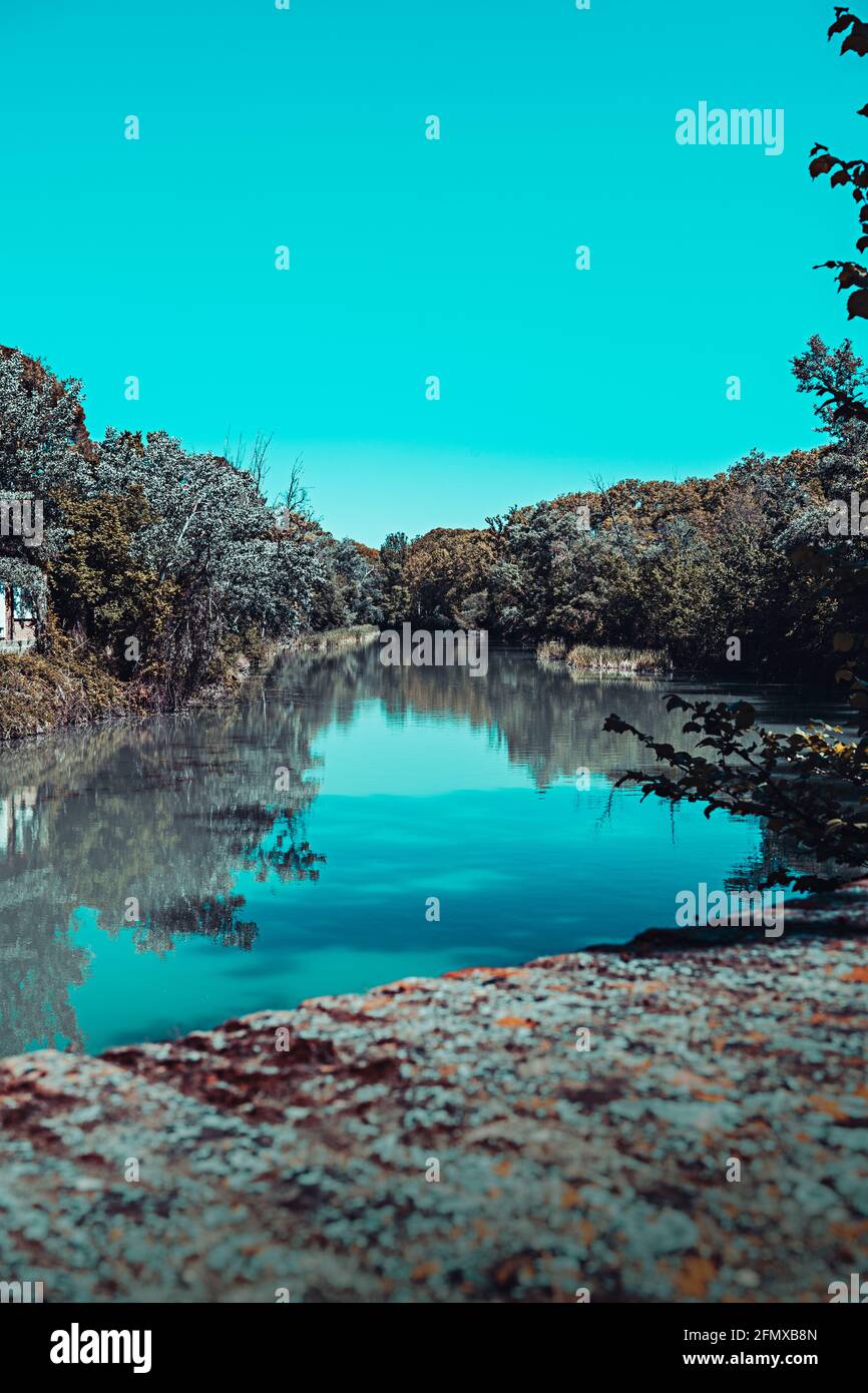 cyab and orange landscape with a river and some beautiful trees Stock ...