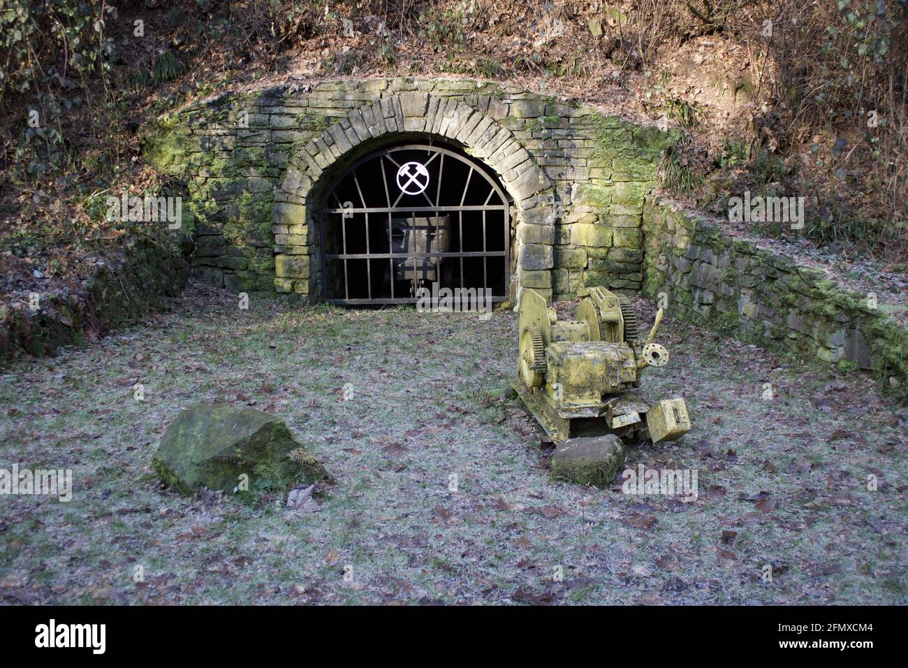 Old mining tunnel entrance with bricked granite stones and an iron gate ...
