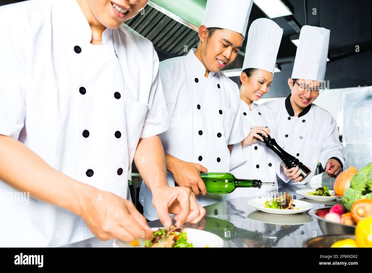 Asian Indonesian chef along with other cooks in restaurant or hotel ...