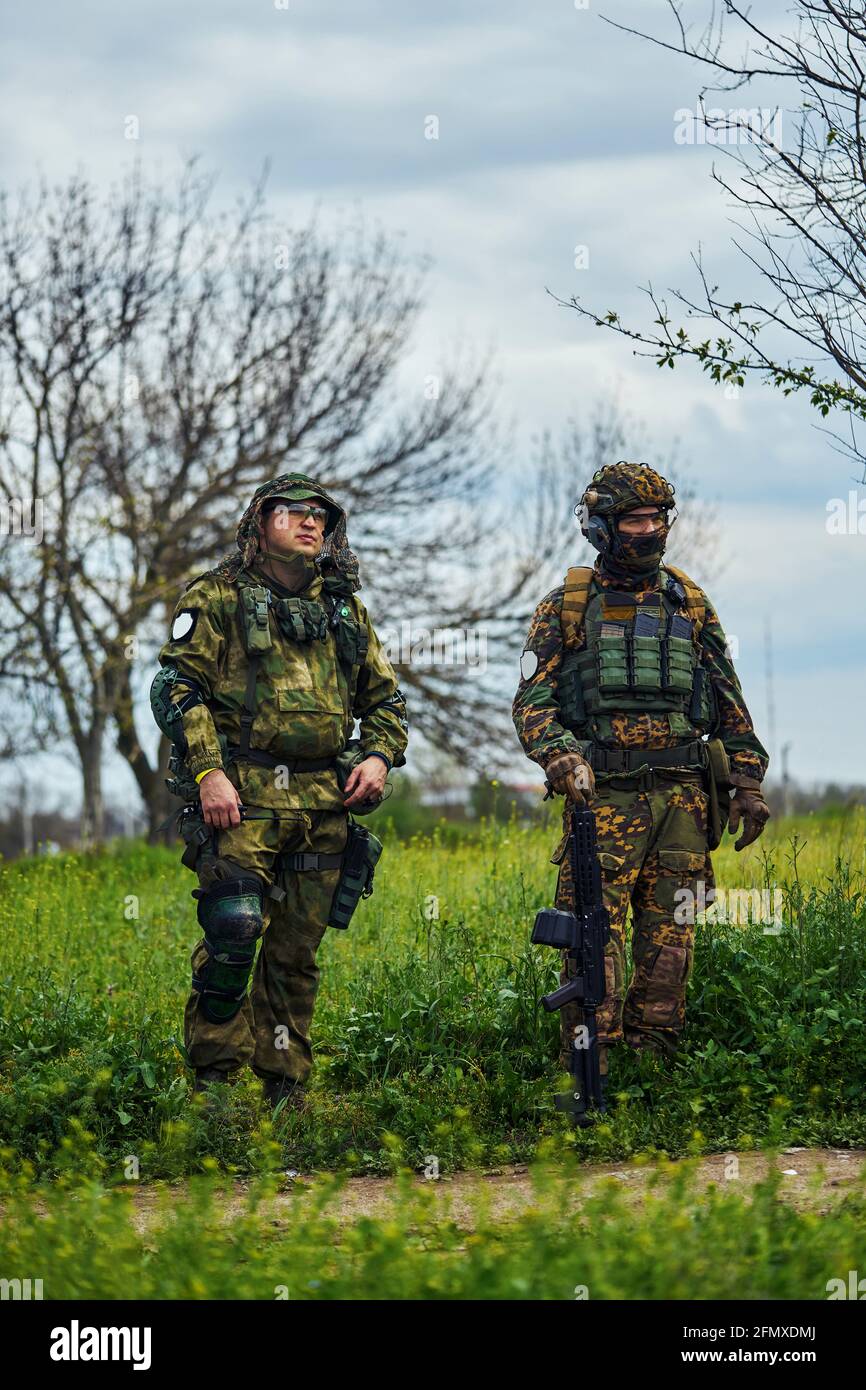 Two airsoft players in outfit with weapons in the field Stock Photo - Alamy