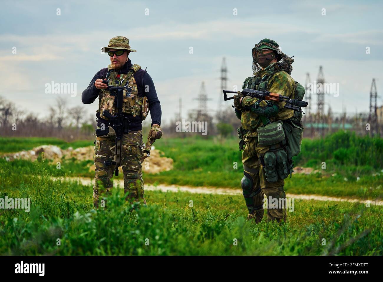Two soldiers with weapons in their hands stand in the field Stock Photo ...
