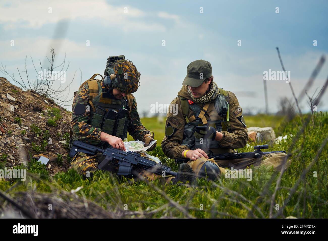 Airsoft players in military uniform watching a map Stock Photo - Alamy
